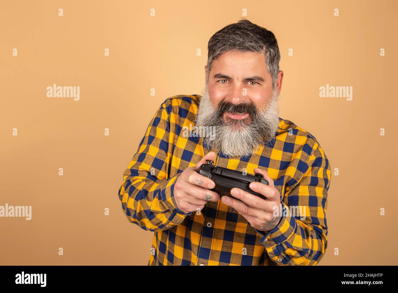 Handsome gamer with a beard playing video game using joystick with an ...
