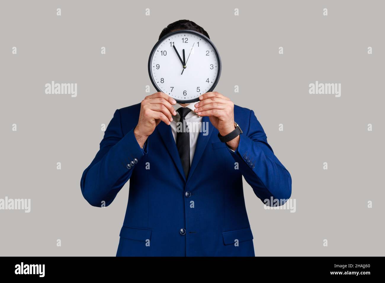 Unknown anonymous man hiding face behind big wall clock, afraid of ...