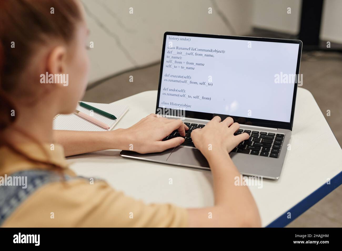 High angle portrait of teenage girl using laptop and coding in ...
