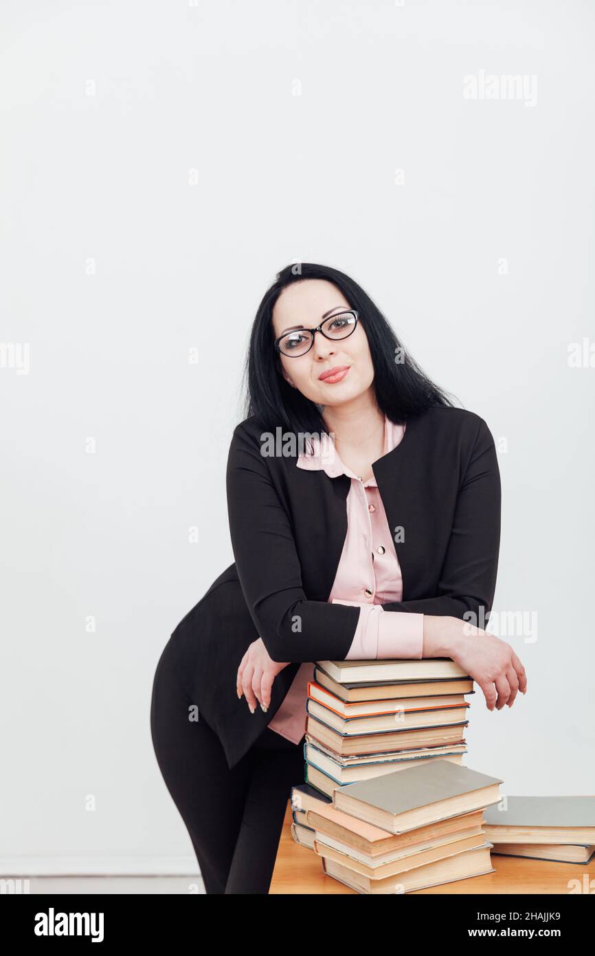 beautiful female teacher at the desk with books for learning Stock ...