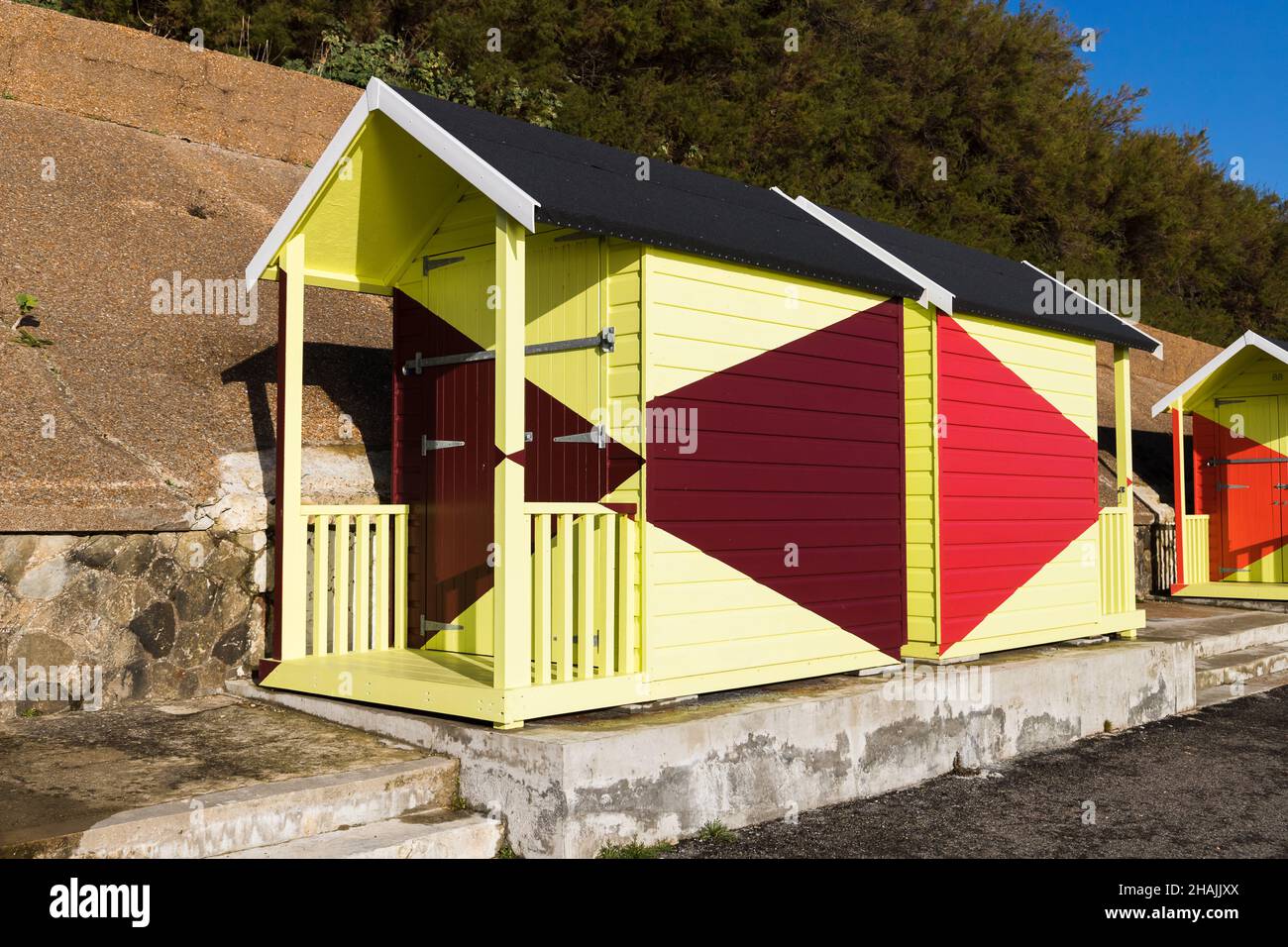 Bright and colourful beach huts on the sea front in Folkestone in Kent ...