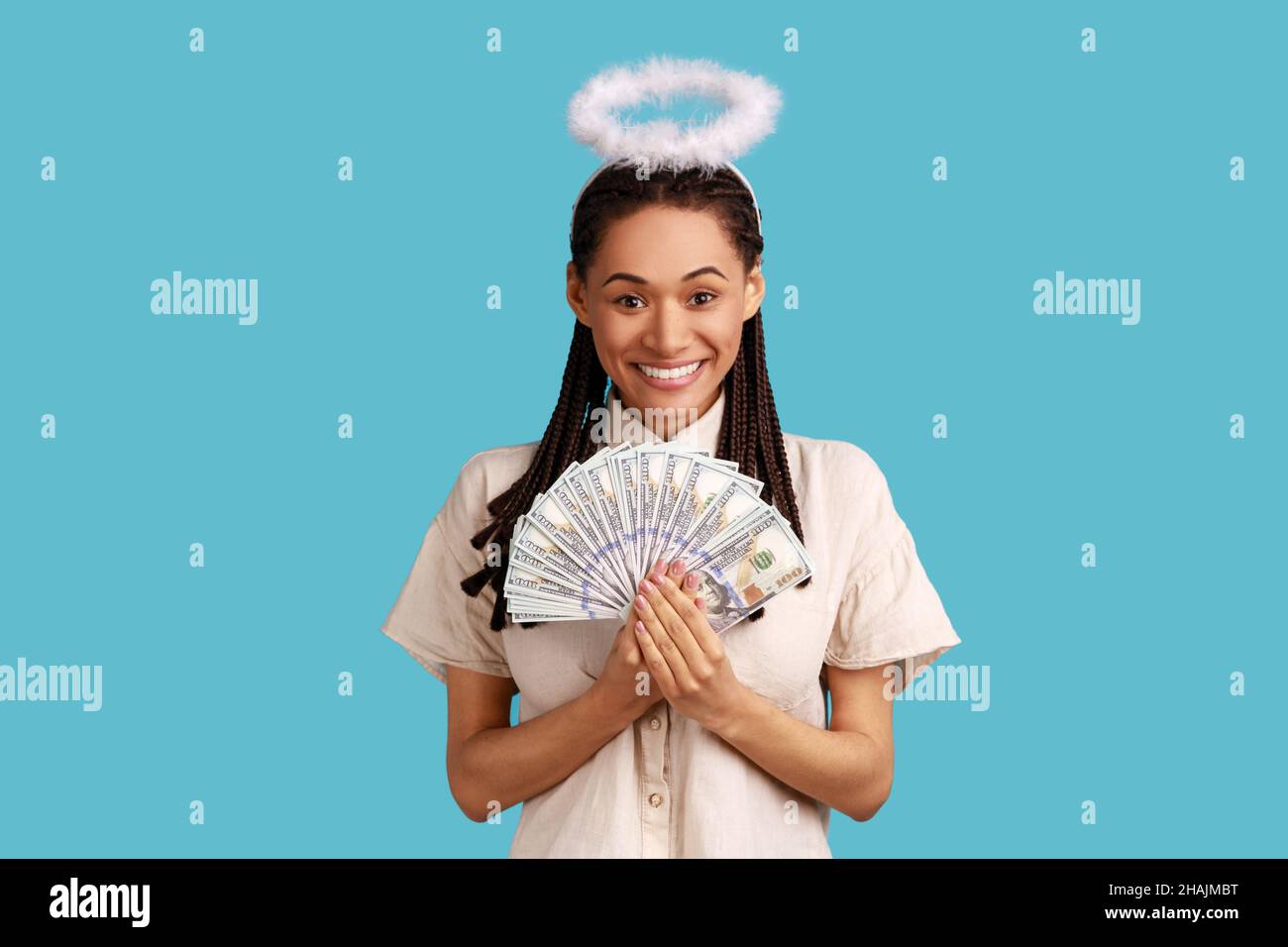 Portrait of satisfied smiling angelic woman with dreadlocks and nimb ...