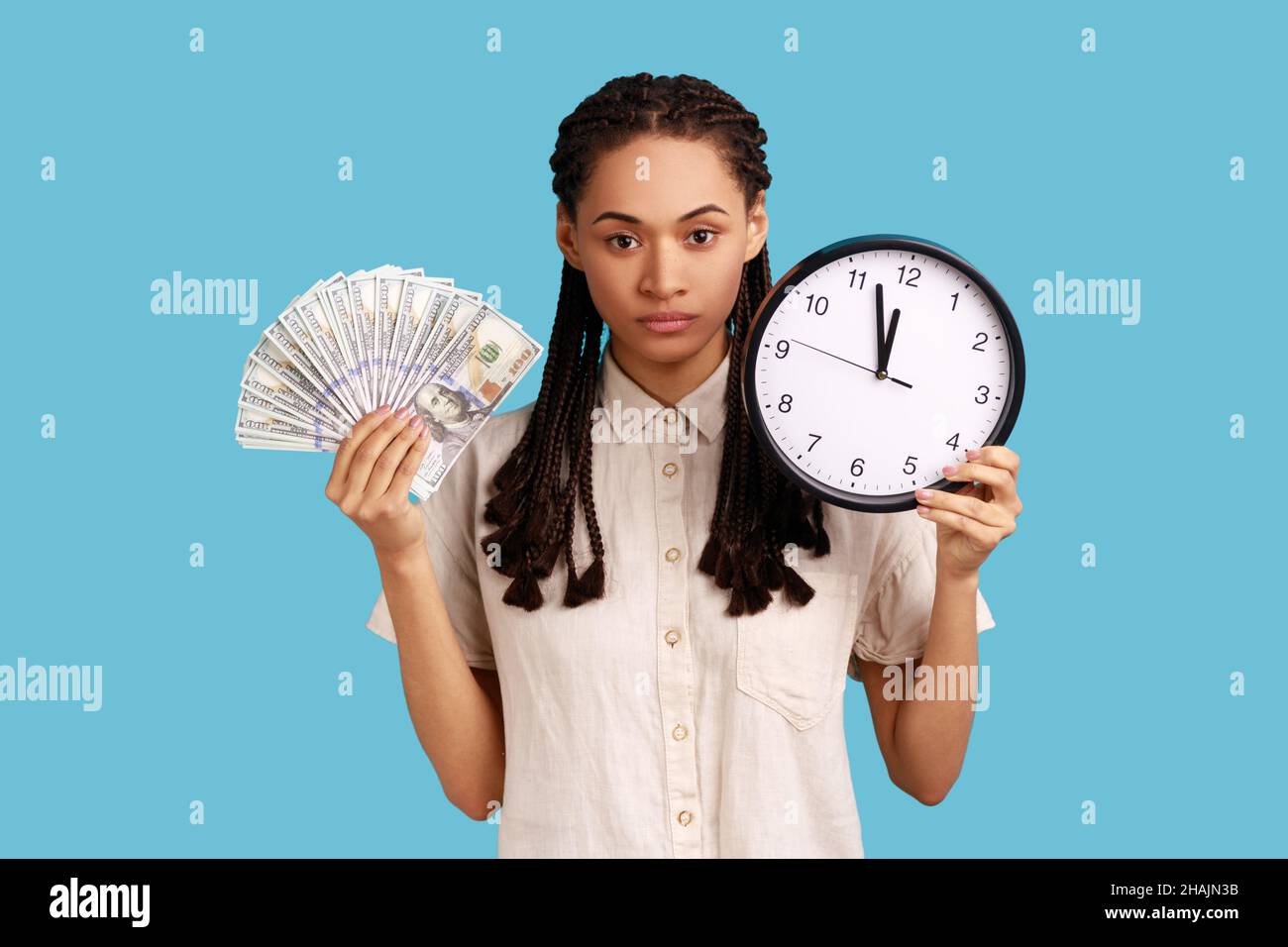 Portrait of serious displeased woman with black dreadlocks holding ...