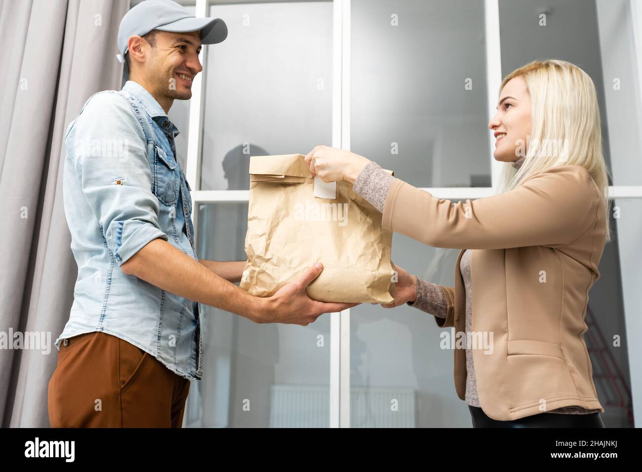 woman receiving package from delivery man Stock Photo - Alamy