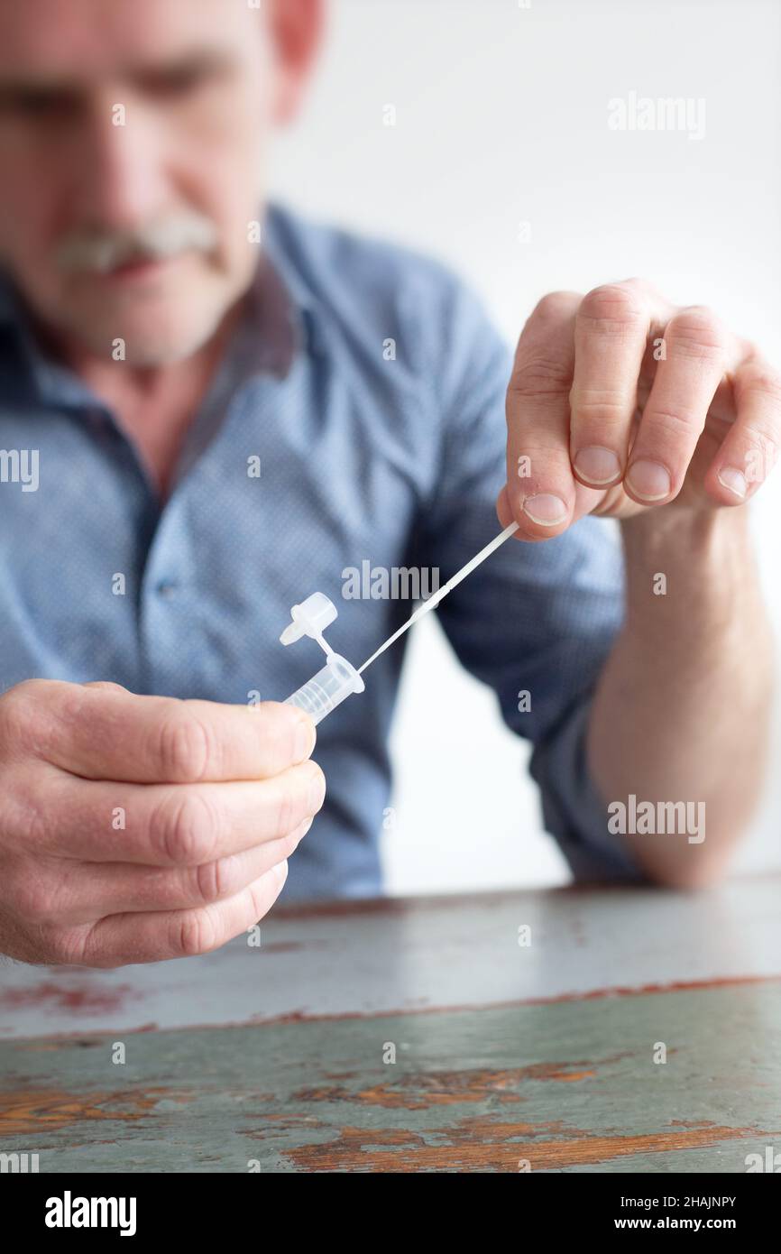 handsome man in his 50s taking a corona self test Stock Photo - Alamy
