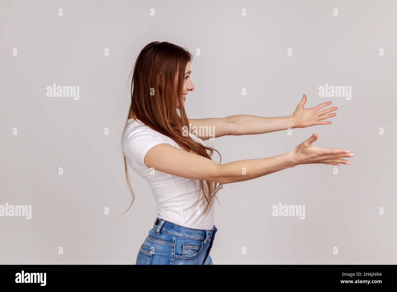 Side view of positive woman giving free hugs with outstretched hands ...