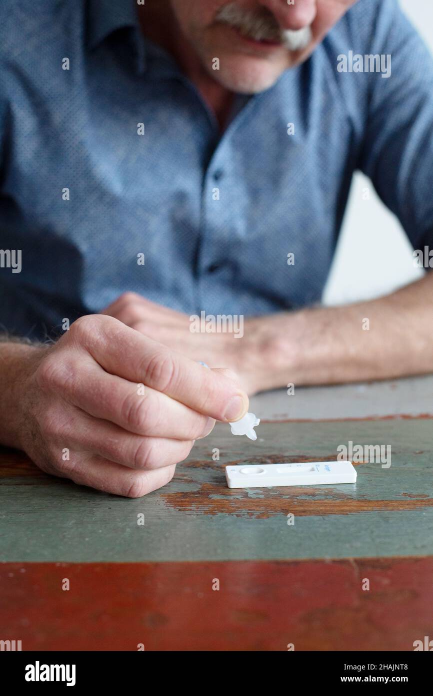 handsome man in his 50s taking a corona self test Stock Photo - Alamy