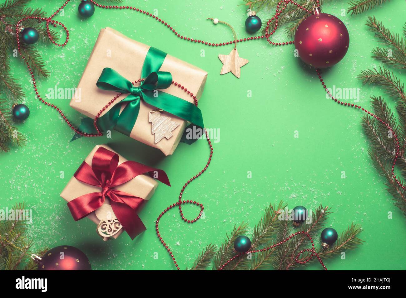 Beautiful Christmas gift boxes on green background with branch of ...