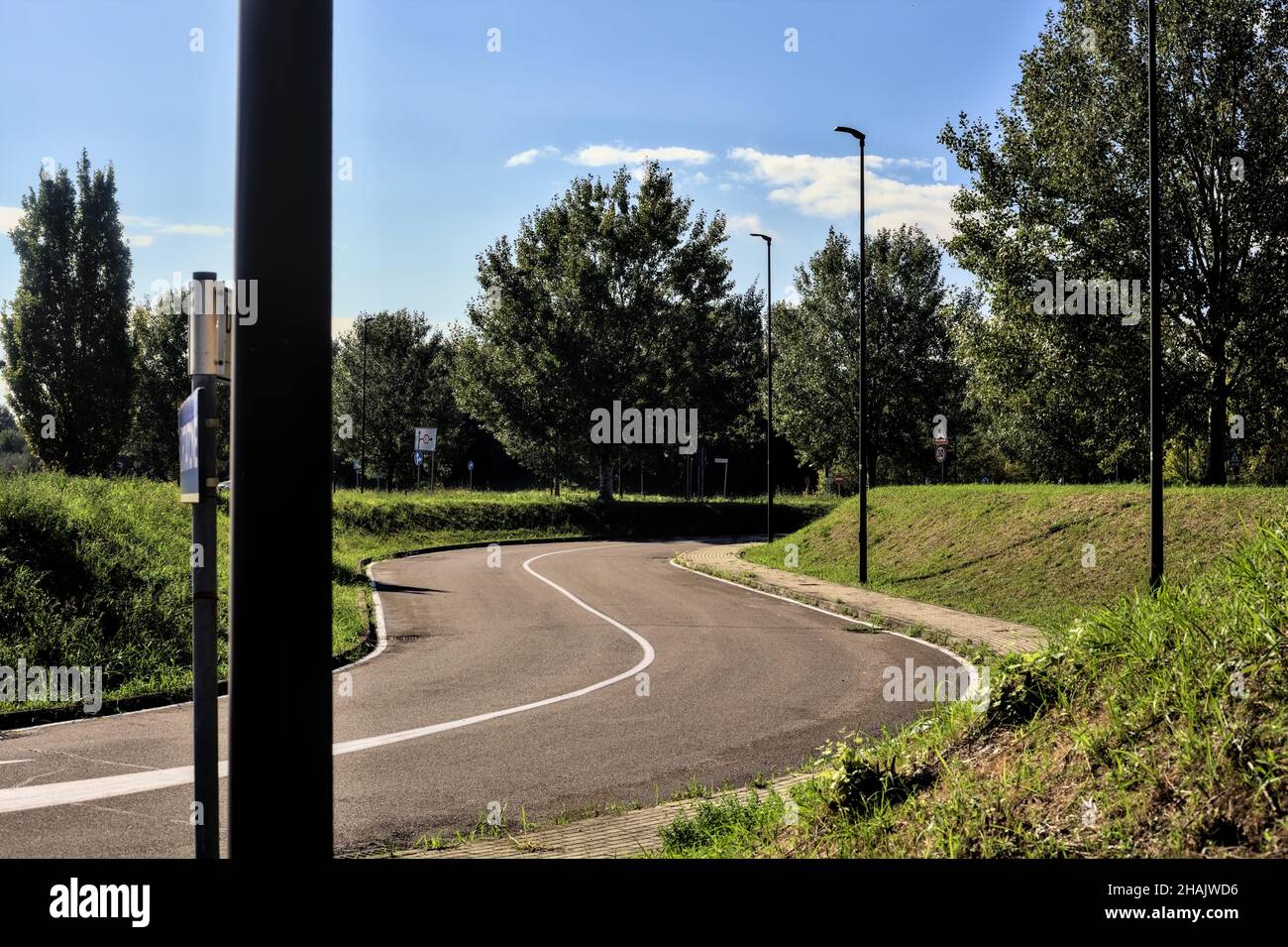 Road bordered by enbankment with trees in the countryside Stock Photo ...