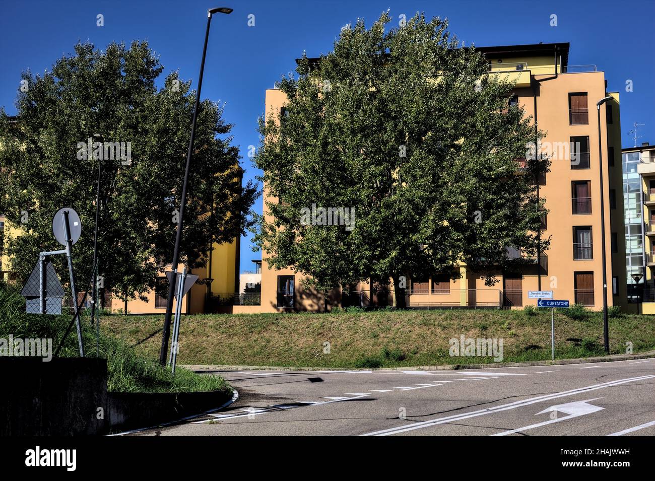 Road in a residential area with a building on its side Stock Photo - Alamy