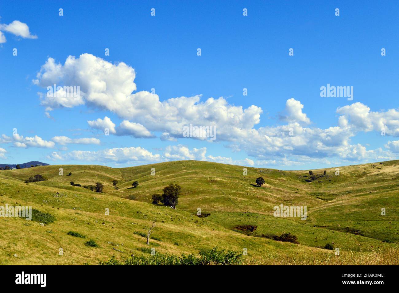 A rolling hillside with white clouds Stock Photo - Alamy