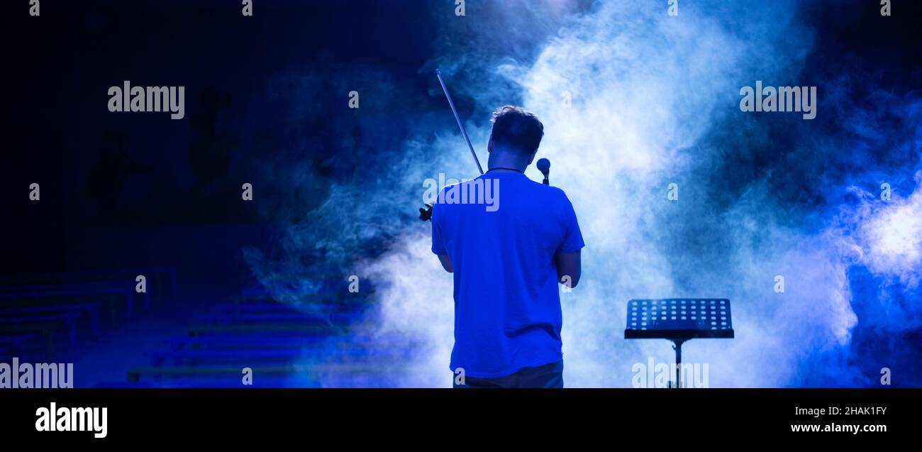 View from the back of a man playing the violin on stage Stock Photo - Alamy