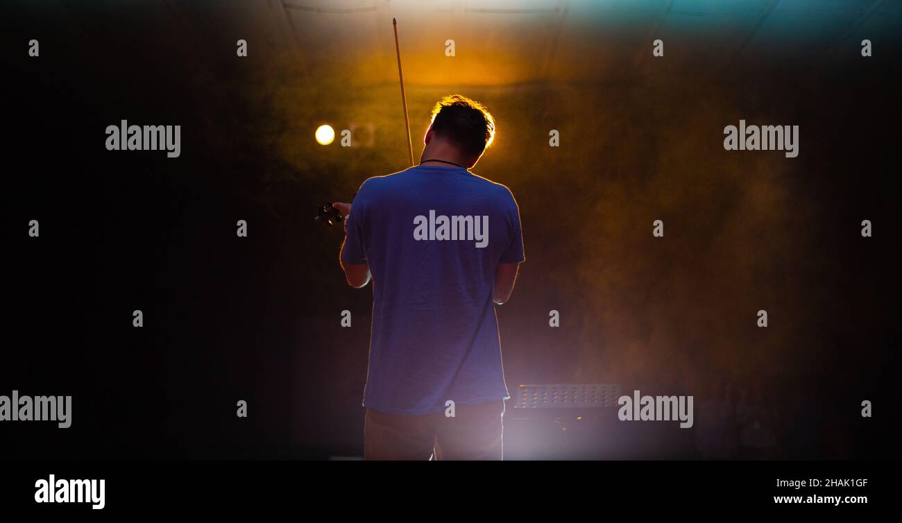 View from the back of a man playing the violin on stage Stock Photo - Alamy