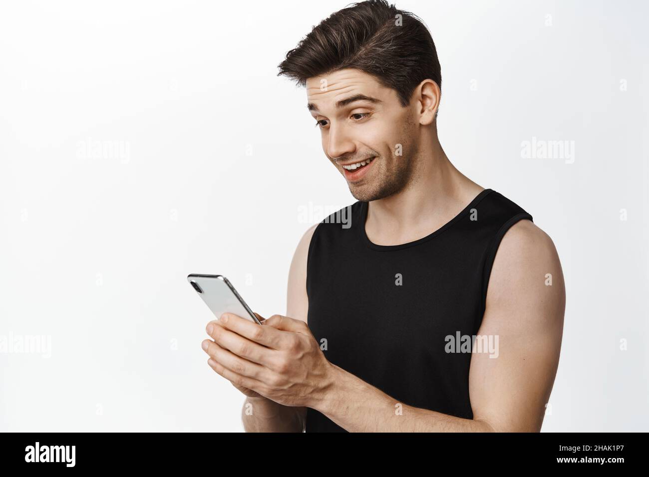 Image of adult caucasian man looking at his phone screen with surprised ...
