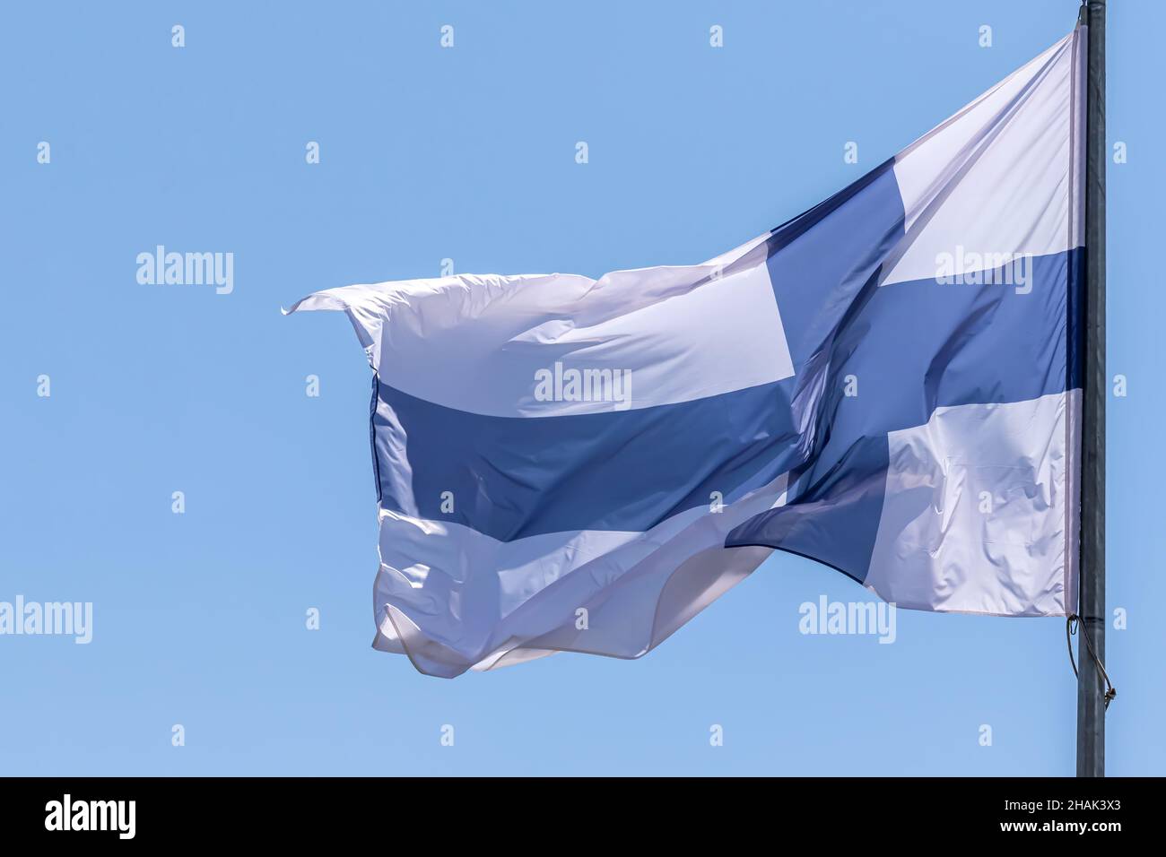 Finnish national flag waving on blue sky background. Republic of ...