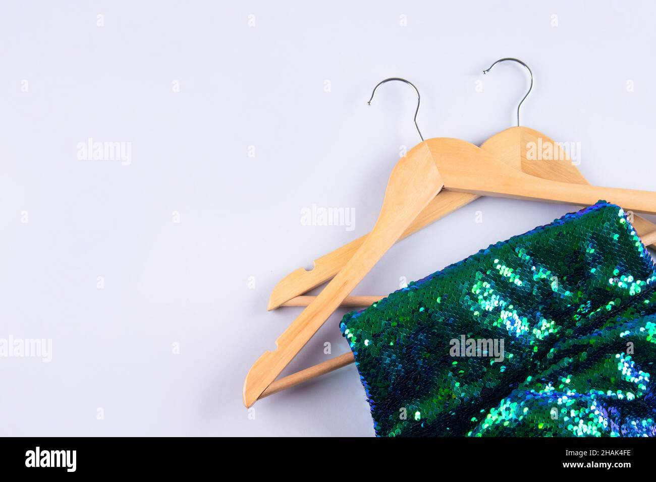 Fashion sequins fabric on hangers on gray background with copy space ...