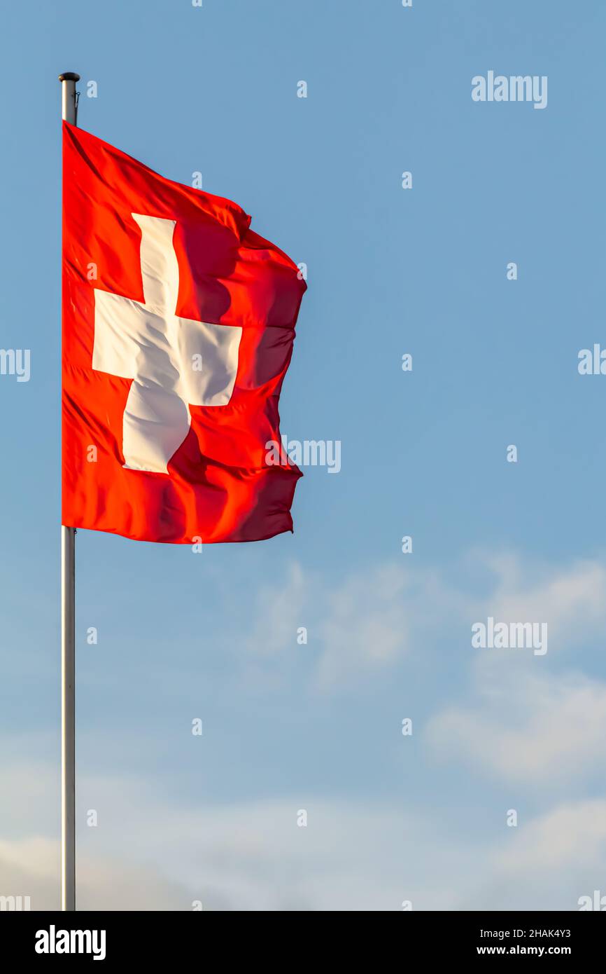Switzerland national flag waving on blue sky background. Swiss ...