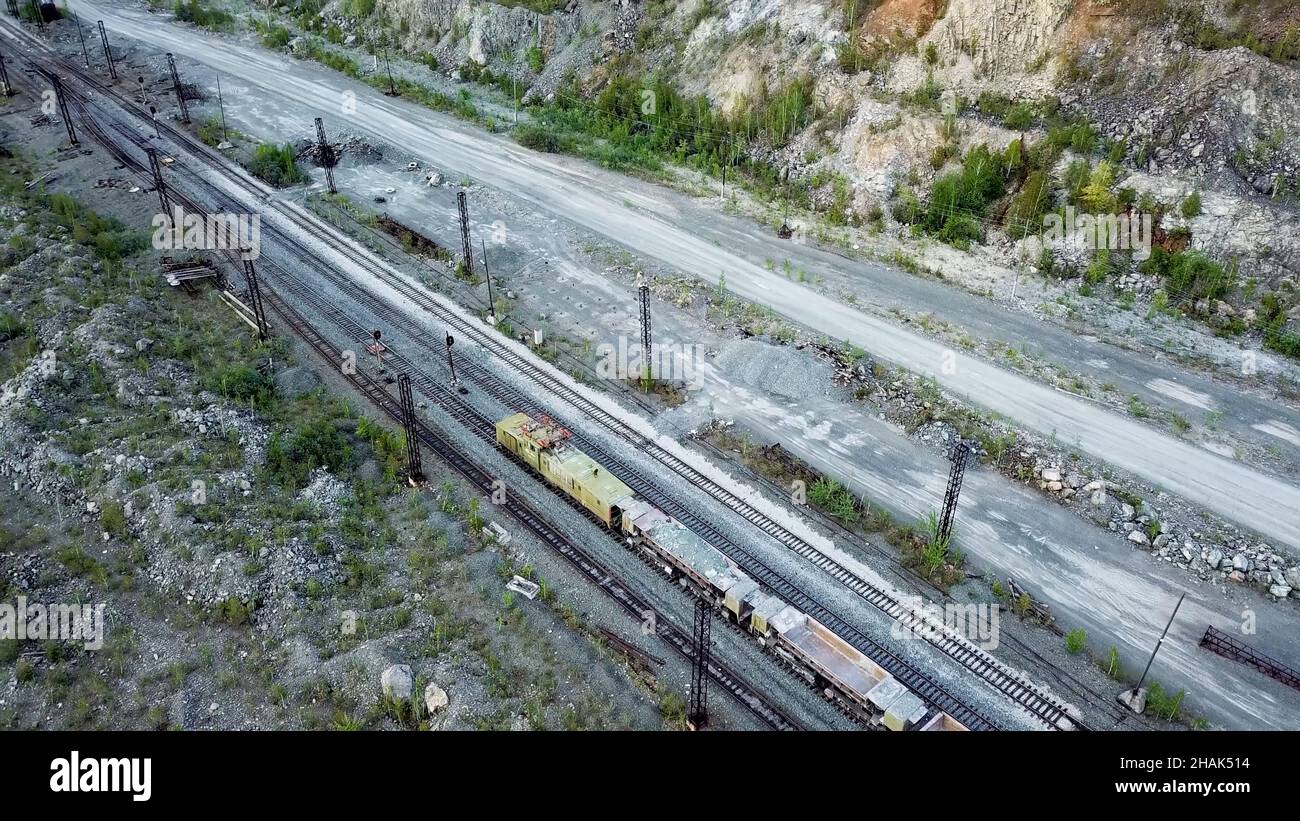 Diesel locomotive is pushing dump-car filled with rubble stone in the ...