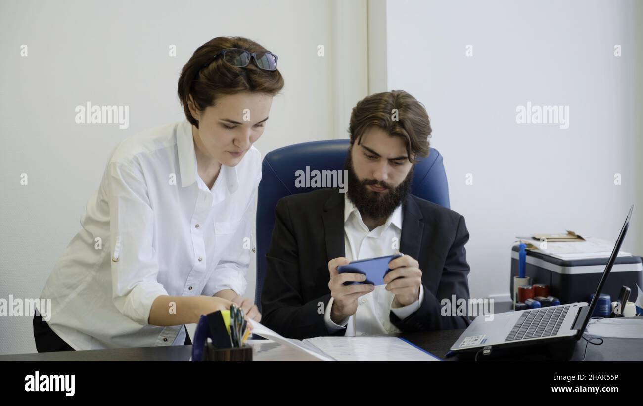 Boss plays the phone when the employee shows him the documents and asks ...