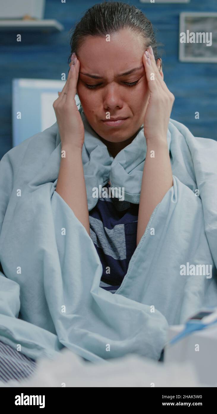 Close up of sick person rubbing temples to cure headache while sitting ...