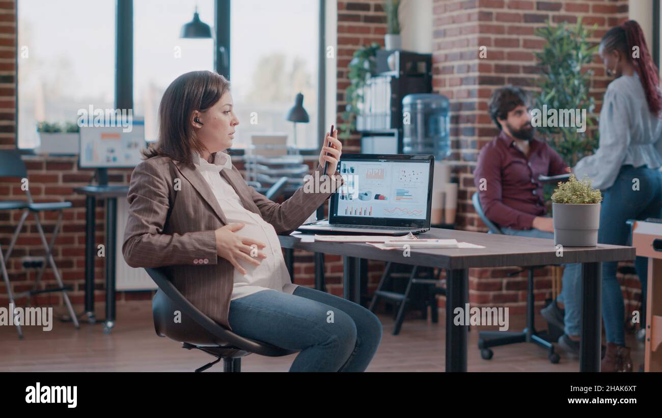 Woman expecting child holding smartphone to talk on video call at ...