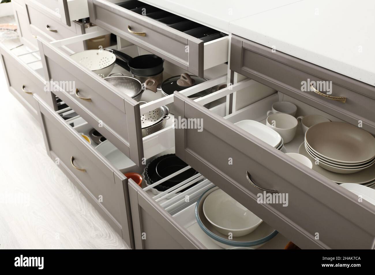 Set of dishes in open kitchen drawers, closeup Stock Photo - Alamy
