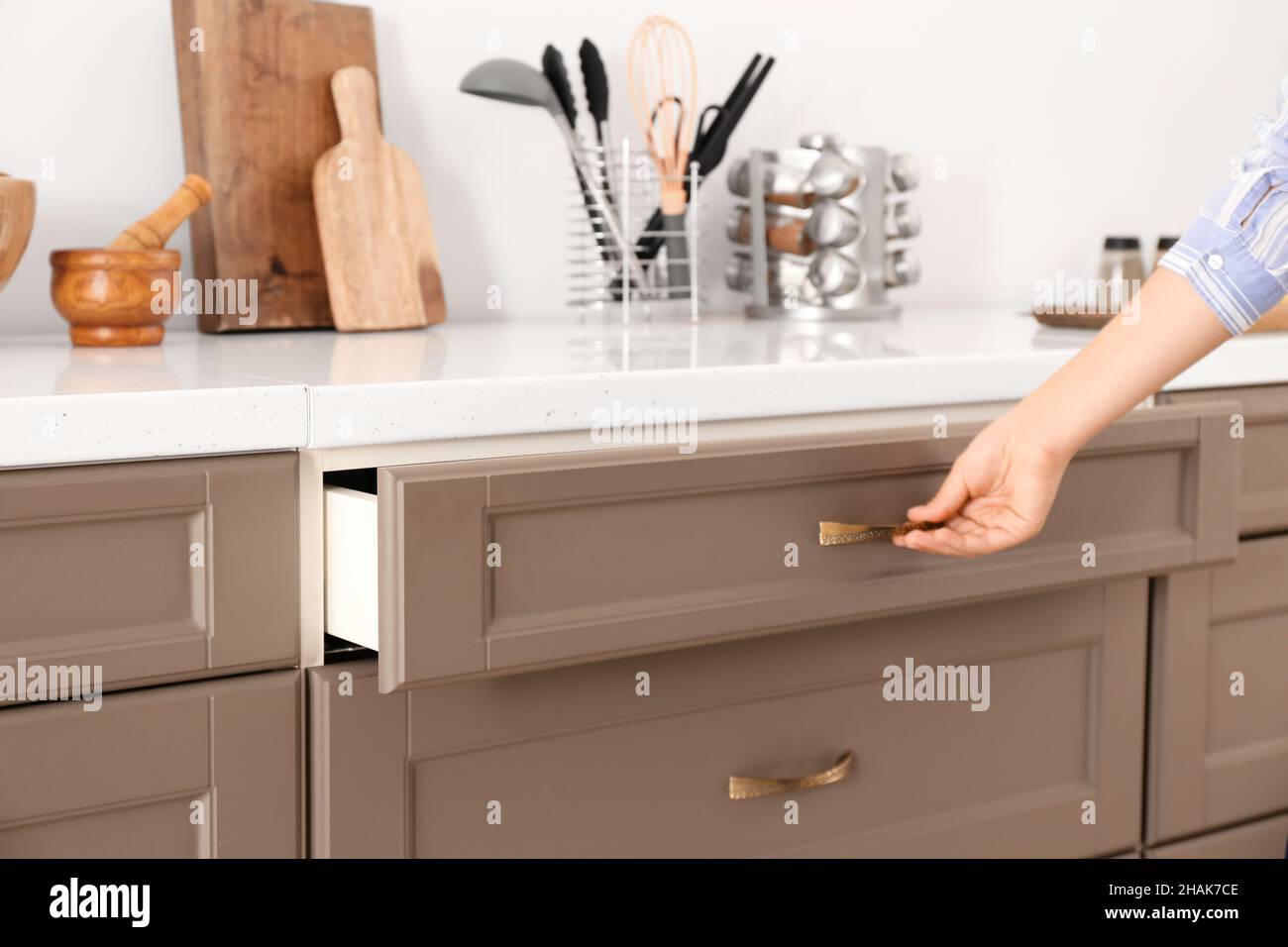 Woman opening drawer with cutlery at home Stock Photo - Alamy