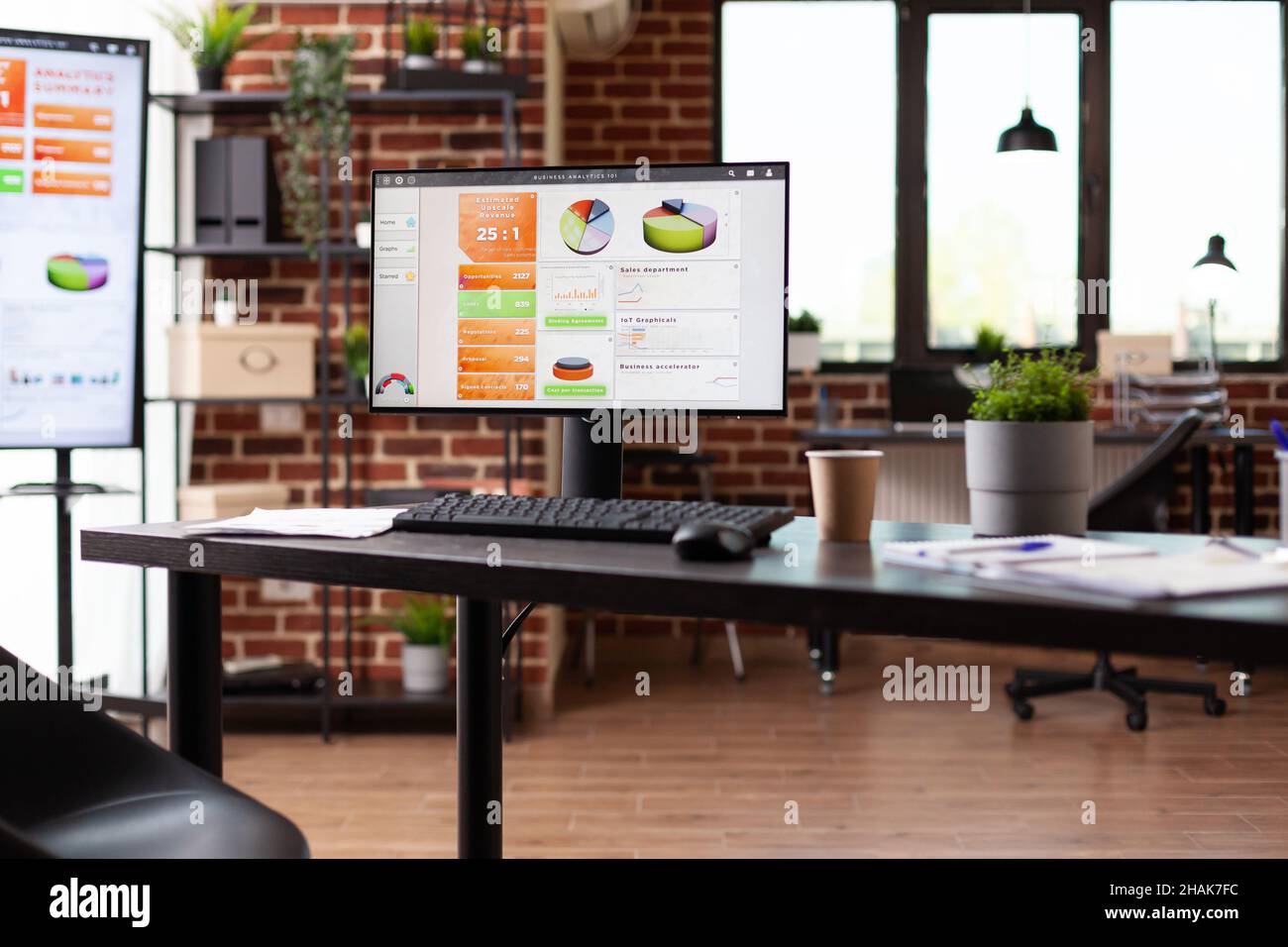Monitor with business charts on table in empty office. Computer with ...