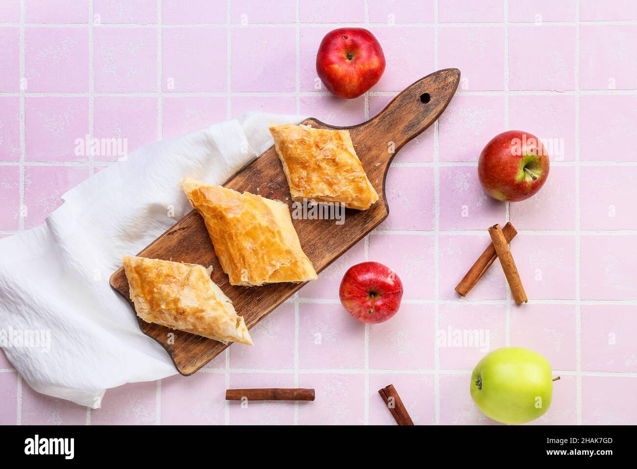 Wooden board with pieces of tasty apple strudel and fresh fruits on ...