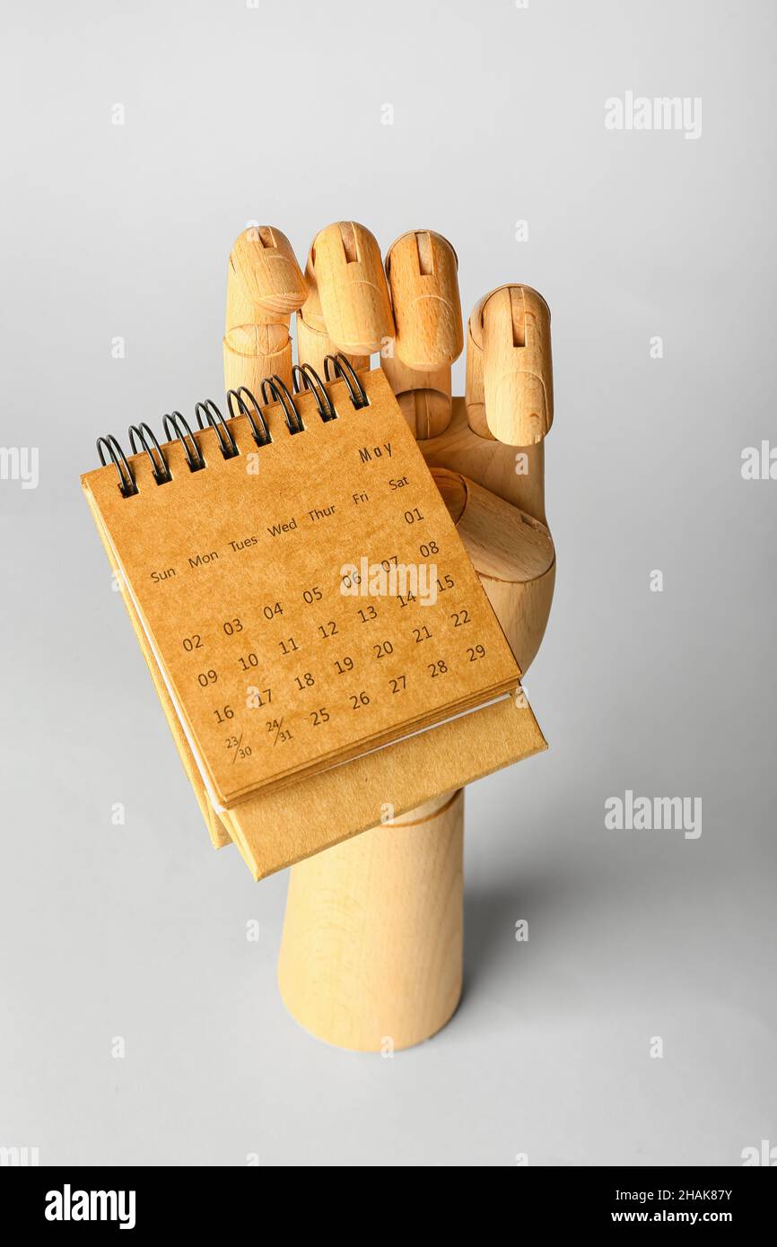 Wooden hand with craft calendar on grey background Stock Photo - Alamy