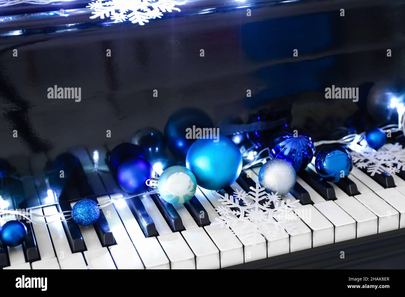 Beautiful Christmas decor with glowing lights on piano keys, closeup ...