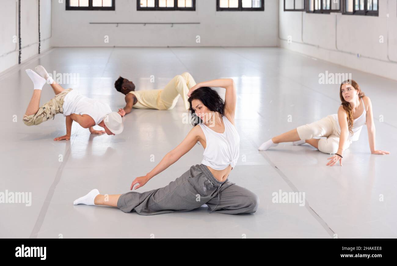 Four dancers exercising modern dance movements in large ball room Stock ...