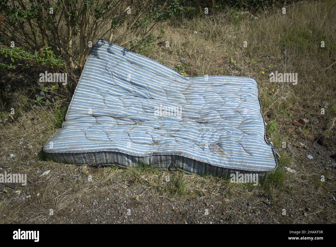 Mattress dumped on wasteland Stock Photo - Alamy