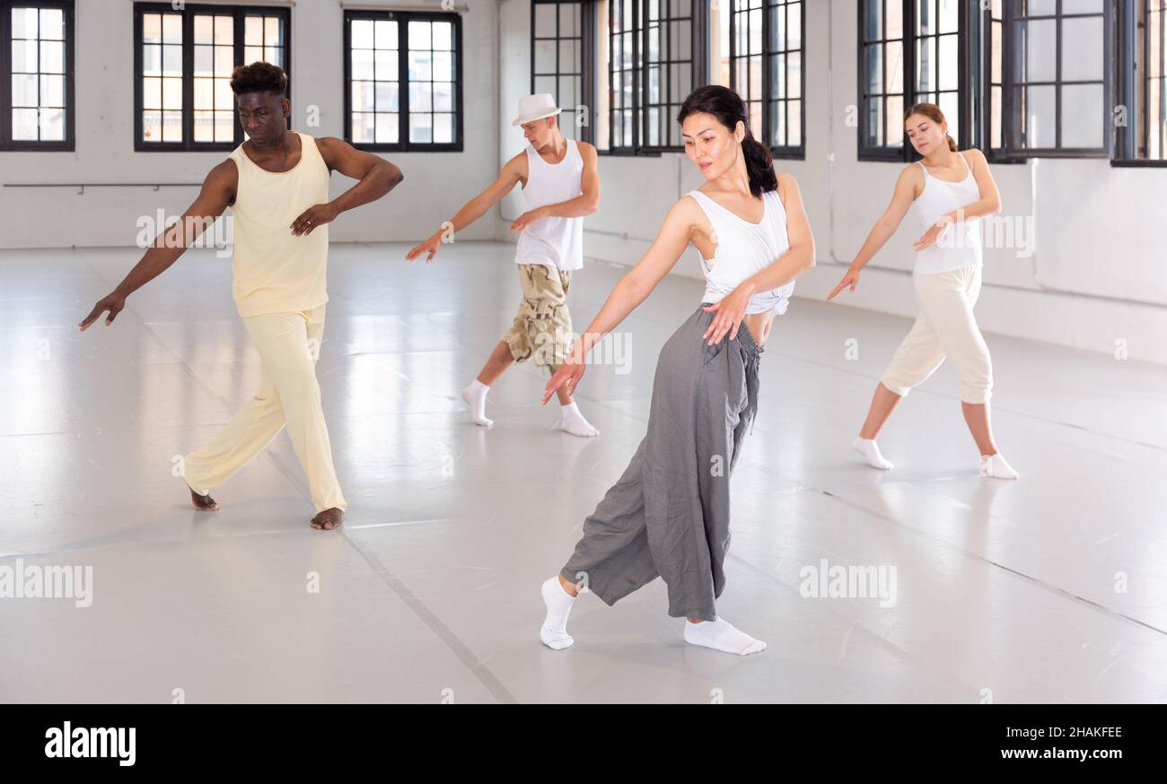 Cheerful people practicing vigorous lindy hop movements in dance class ...