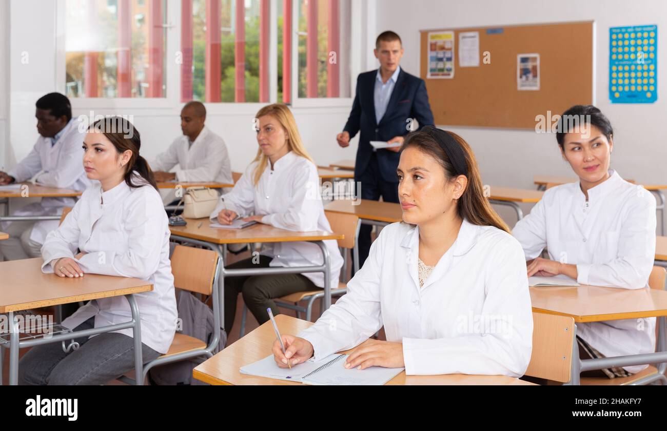 Medical students writing in notepads during lesson Stock Photo - Alamy