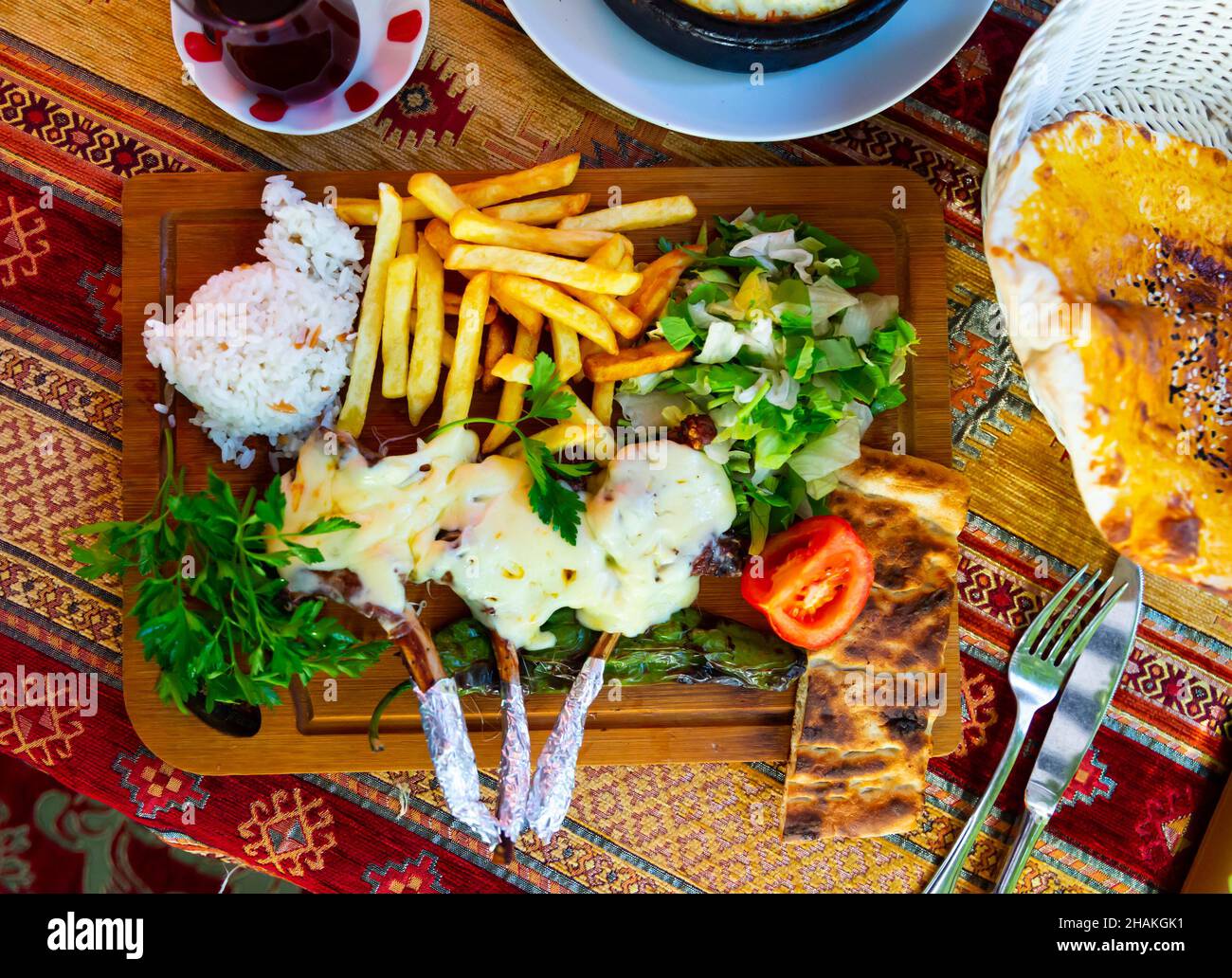 Grilled lamb chops with sauce, pita, rice and potatoes served on a ...