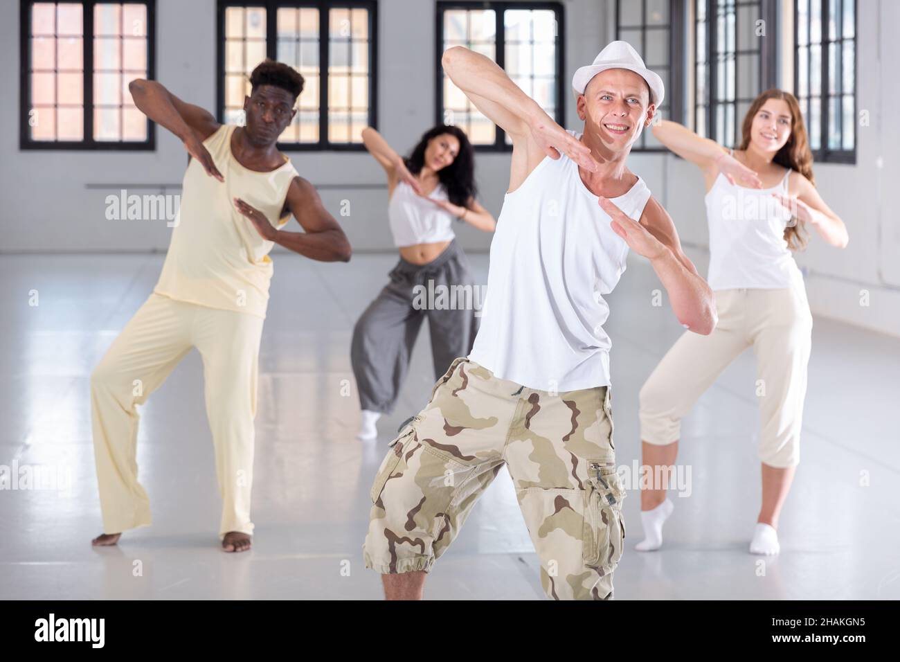 Four dancers exercising modern dance movements in large ball room Stock ...
