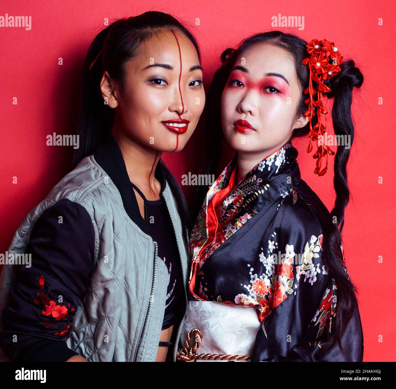 two pretty geisha friends: modern asian woman and traditional wearing ...