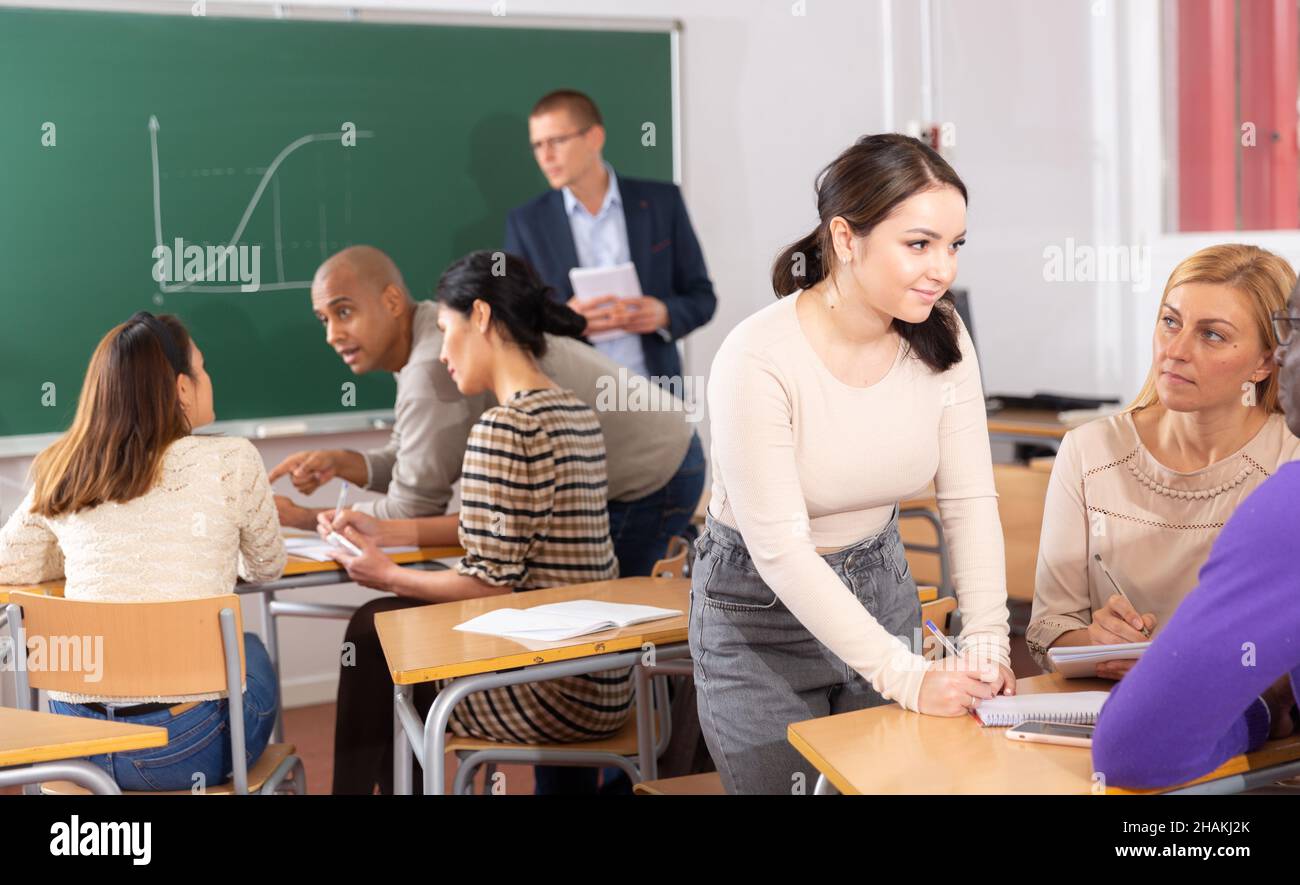 Positive students are talking about homework at the desk Stock Photo ...