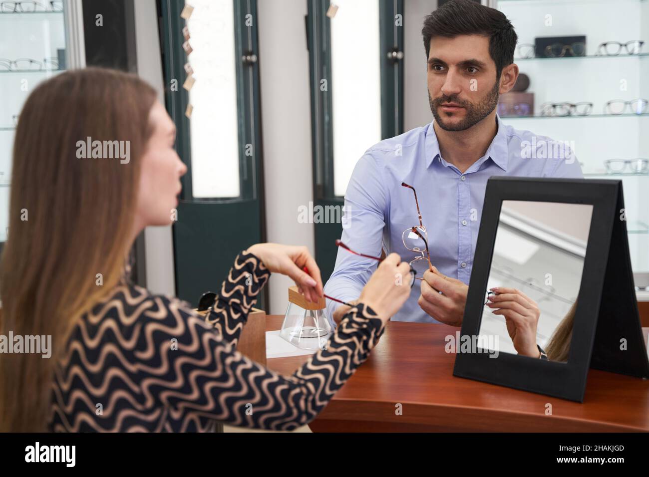 Optician shop worker looking at woman during glasses presentation Stock ...