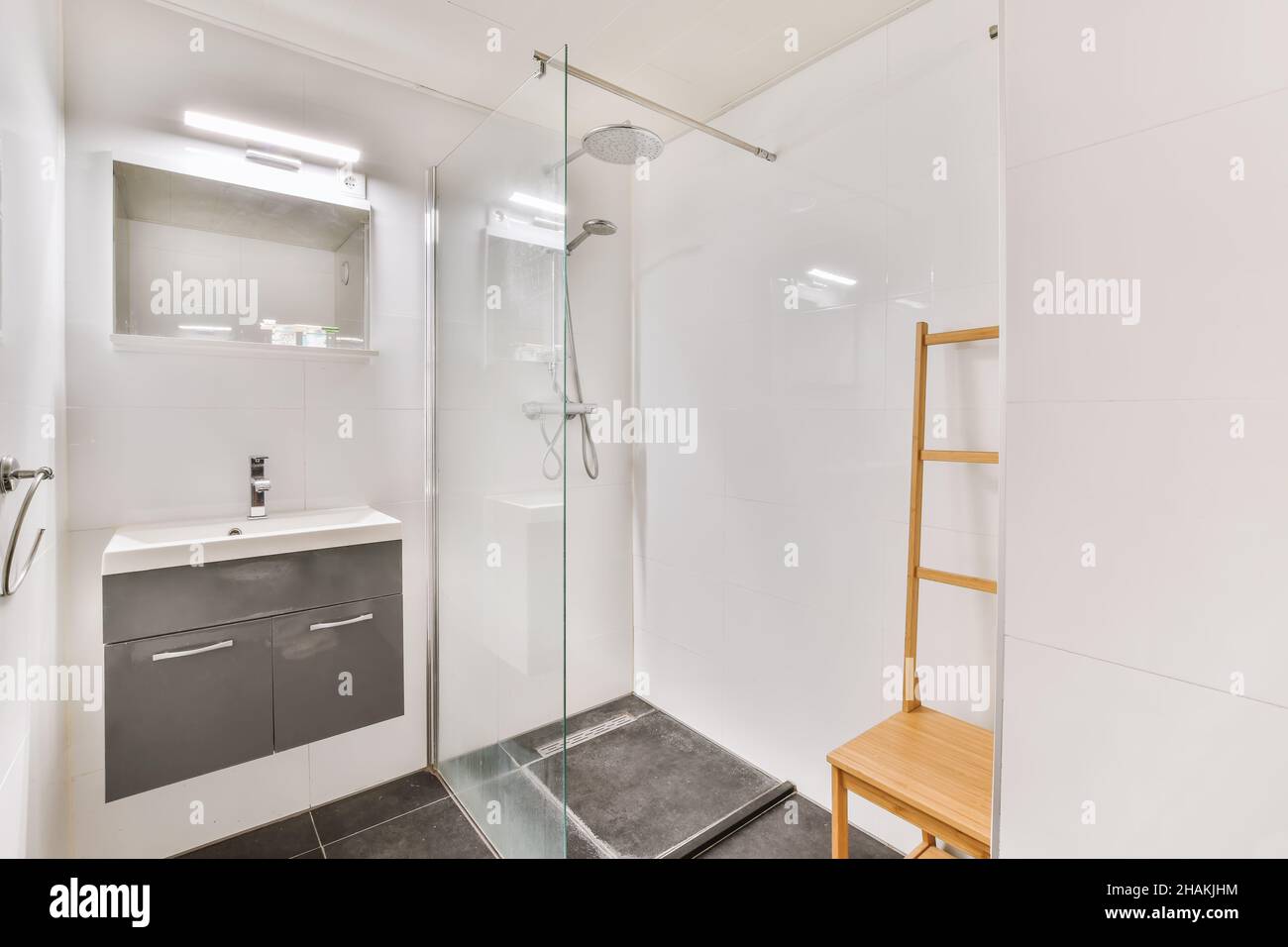 Stylish small bathroom with long back wooden stool Stock Photo - Alamy