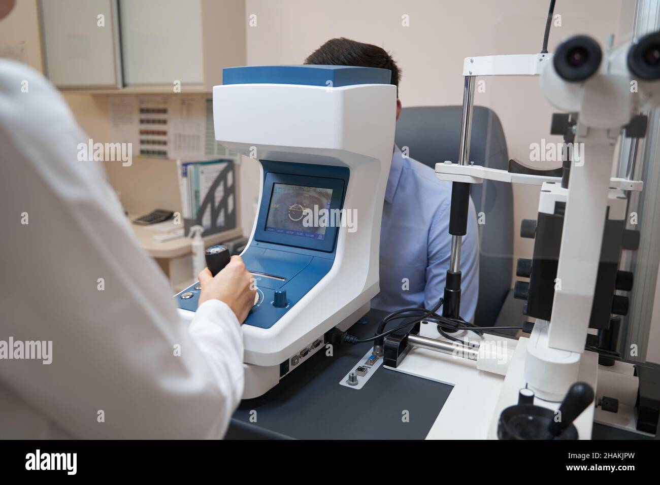 Eye physician checking man sight with autorefractor Stock Photo - Alamy