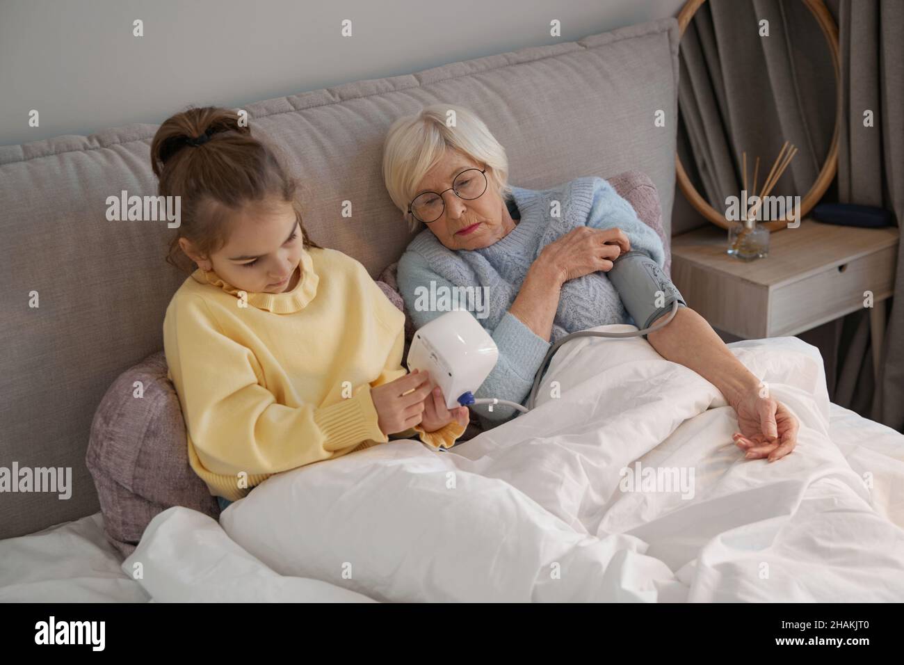 Caring granddaughter assisting her grandma with medical procedure Stock ...