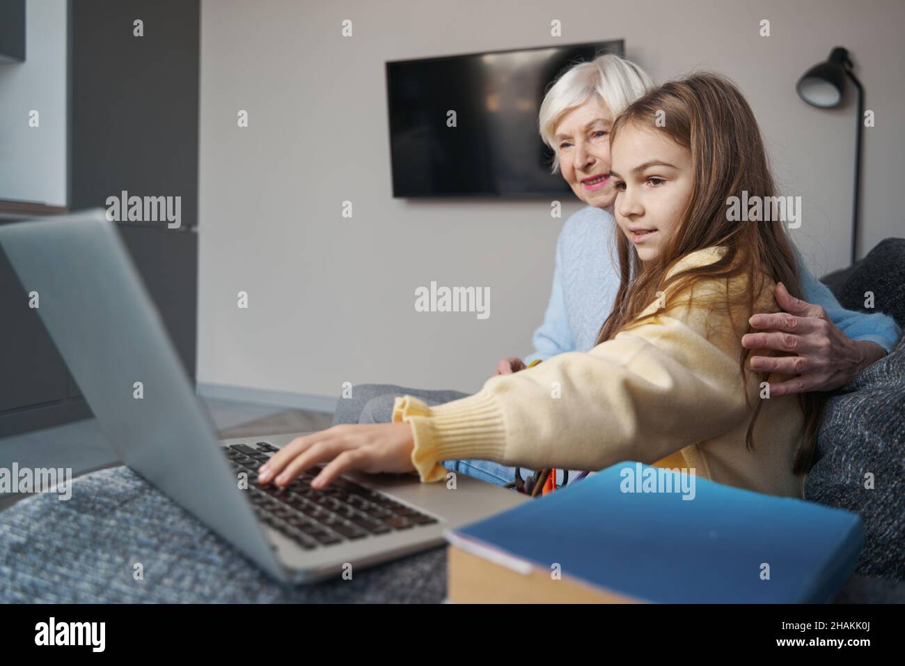 Techsmart kid showing her grandmother how to use a laptop Stock Photo ...