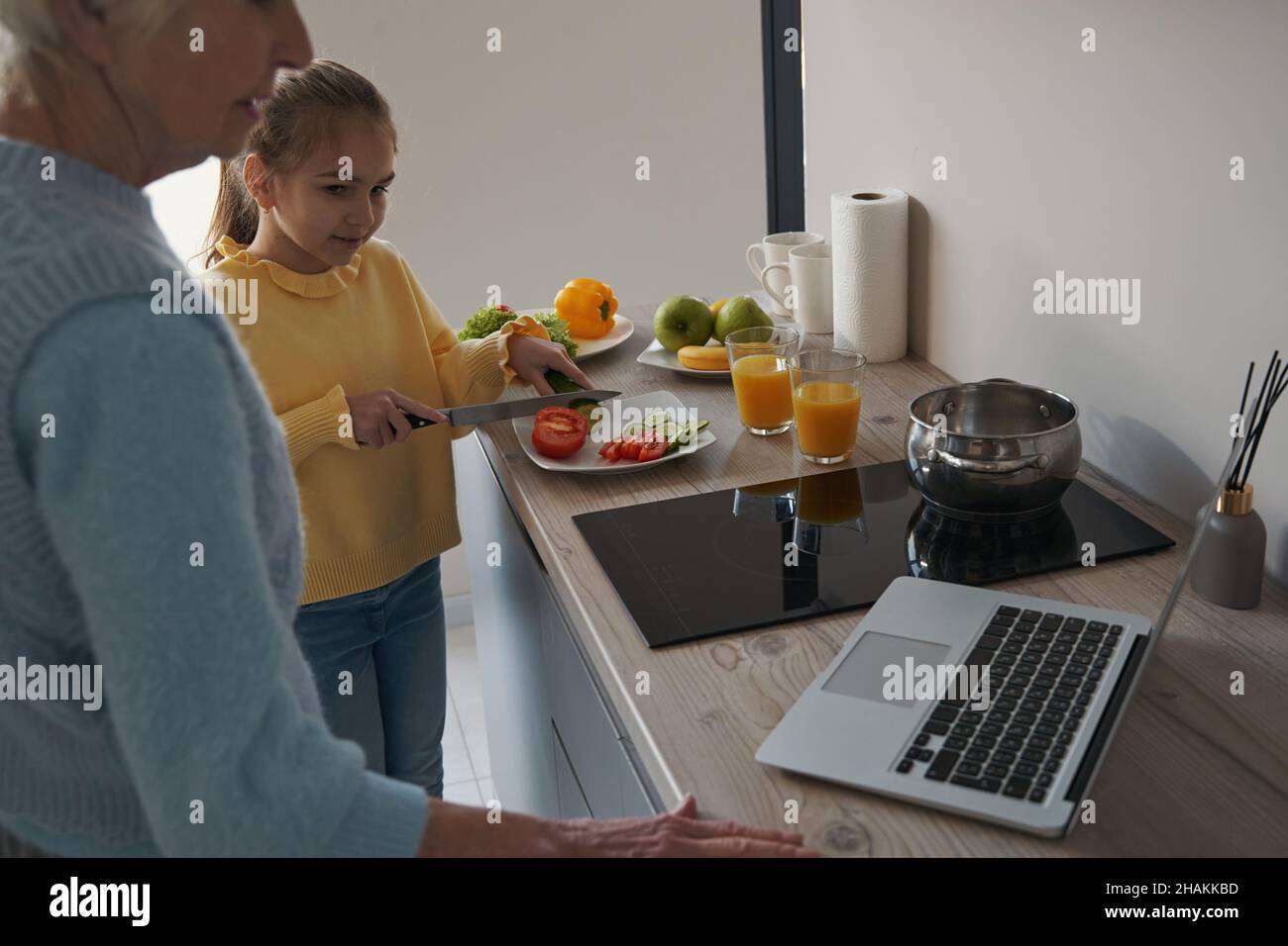 Curious child learning how to cook from her skilled grandmother Stock ...