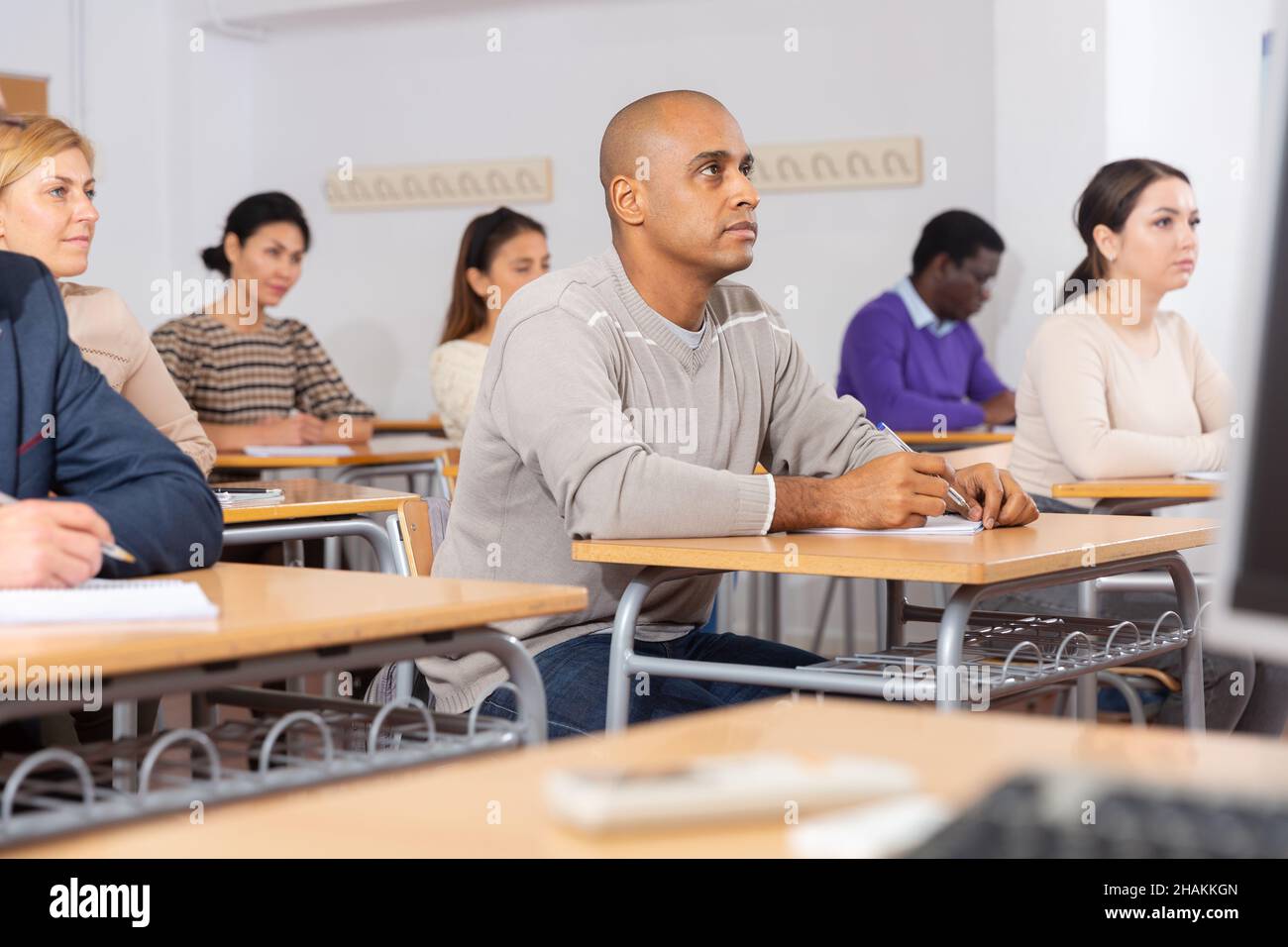 Portrait of a student at a desk in university audience Stock Photo - Alamy