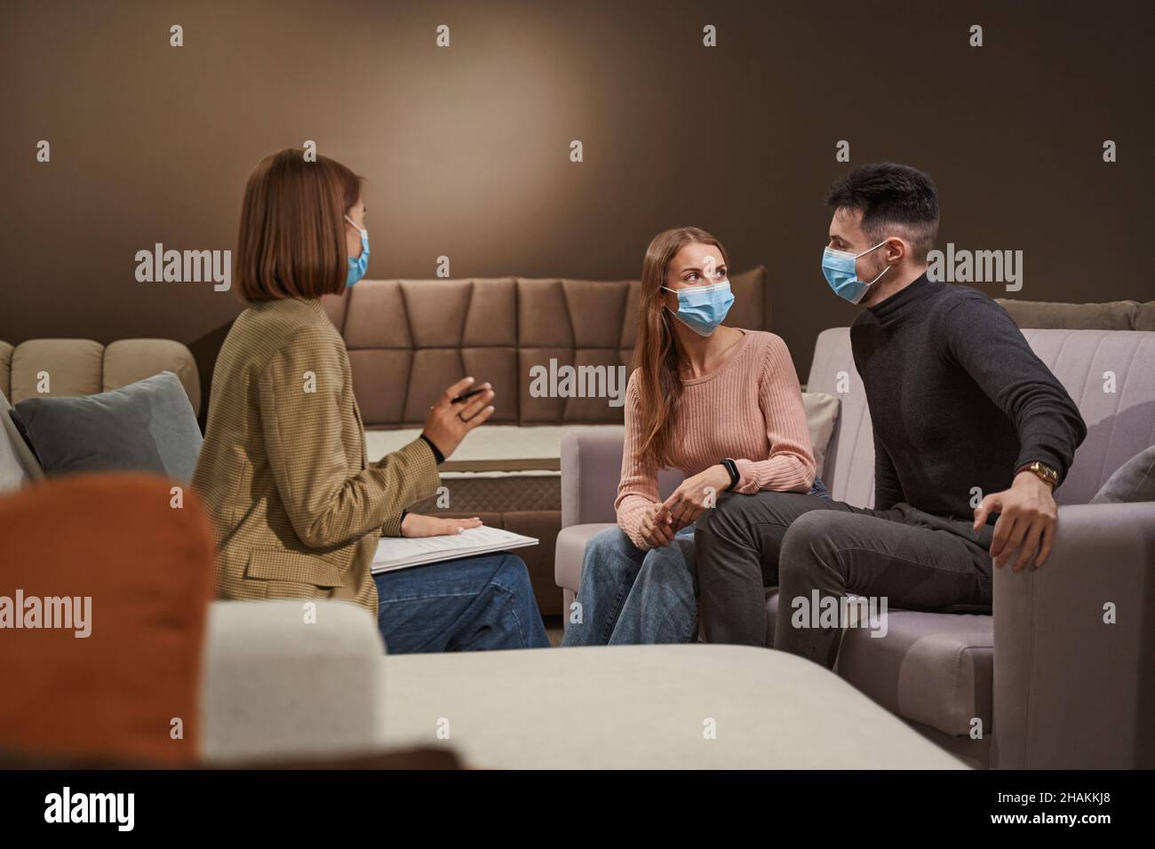 Furniture store customers having conversation in presence of salesclerk ...