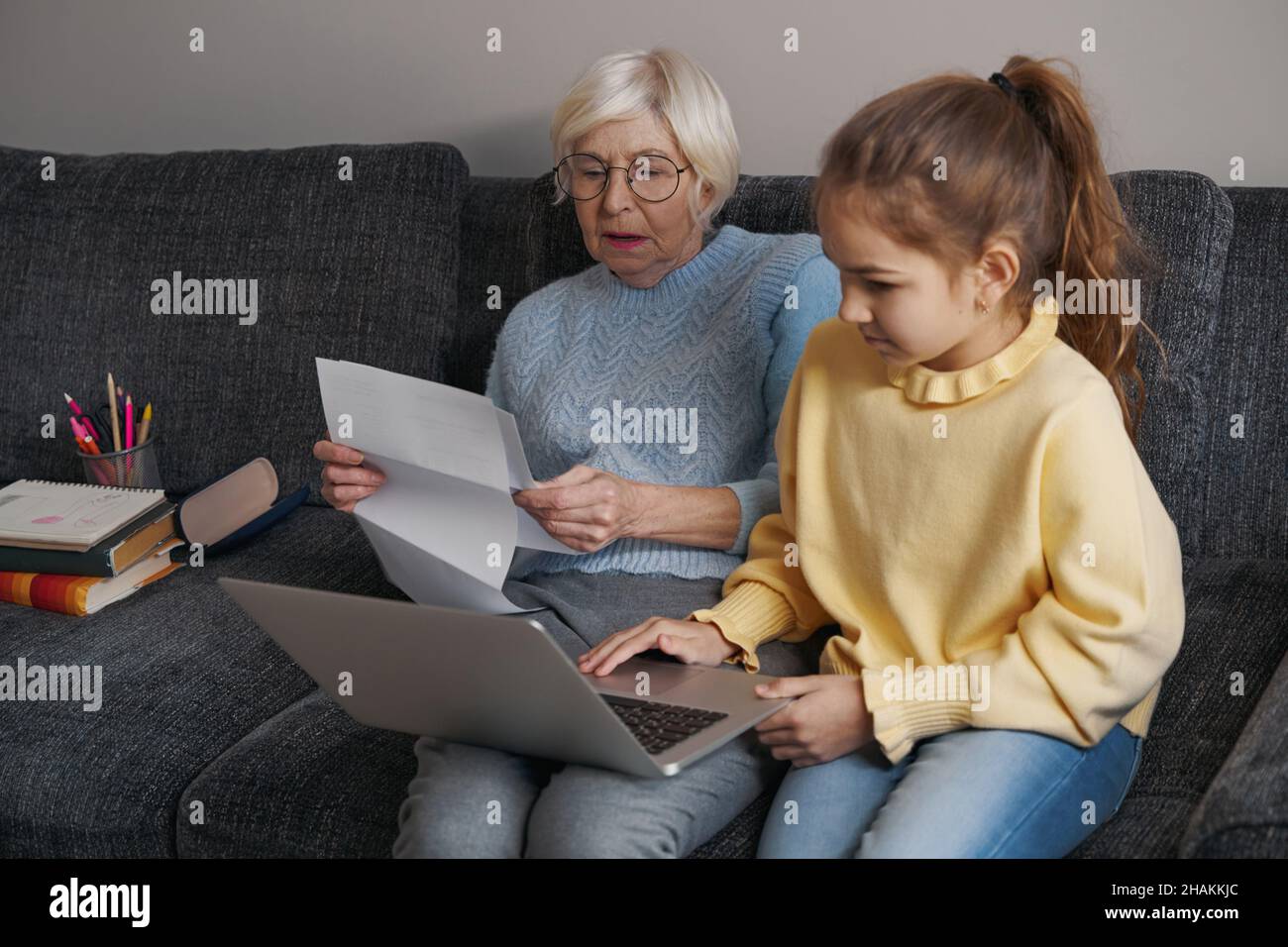 Reserved senior lady and little girl handling paperwork Stock Photo - Alamy