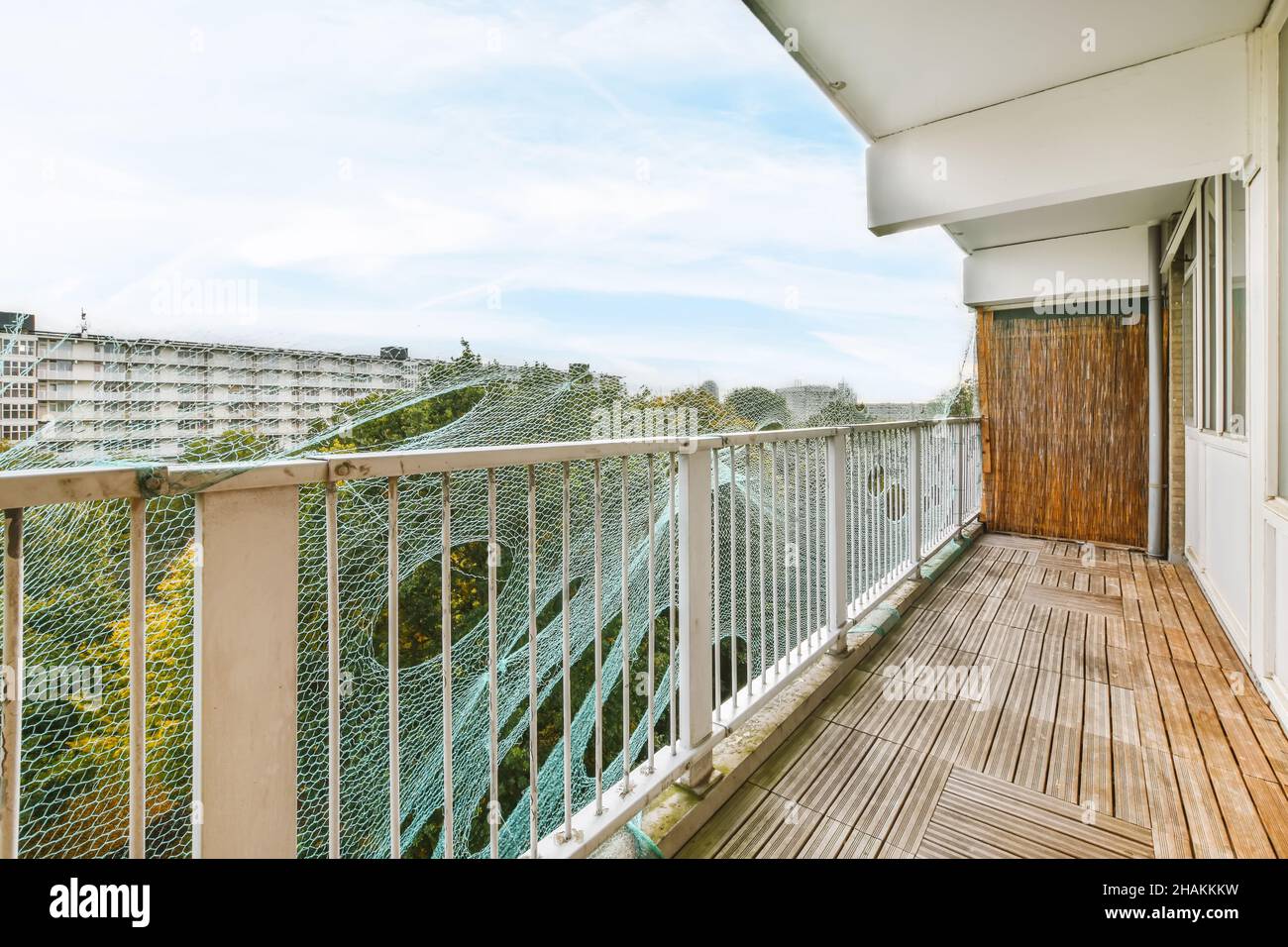 Long narrow balcony with wooden floor and mesh near the handrails Stock ...