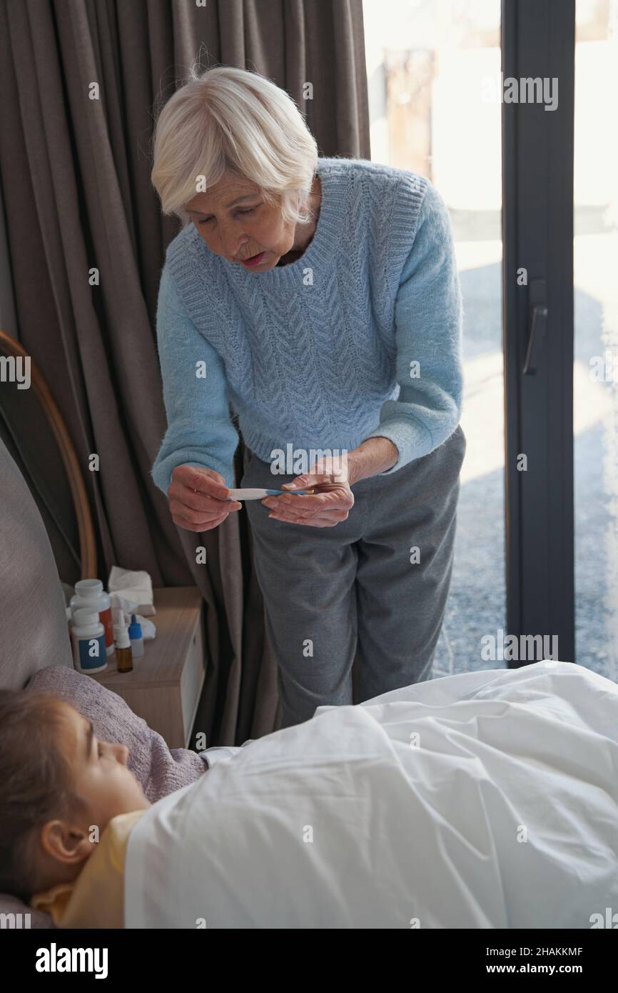 Senior lady nursing sick kid back to health Stock Photo - Alamy
